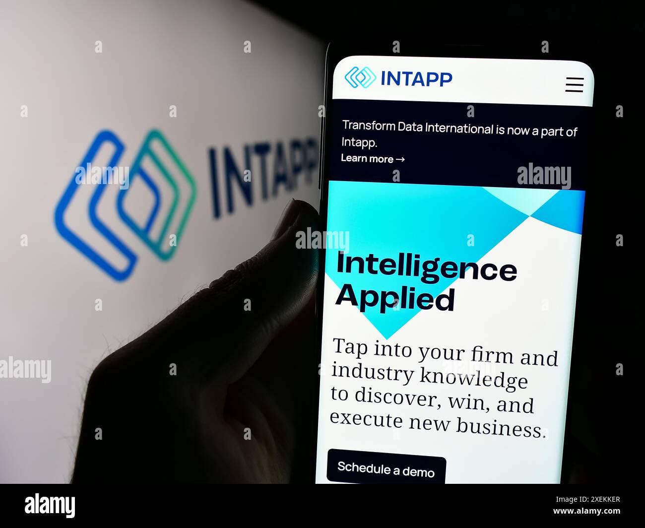 Person holding cellphone with webpage of US software company ...