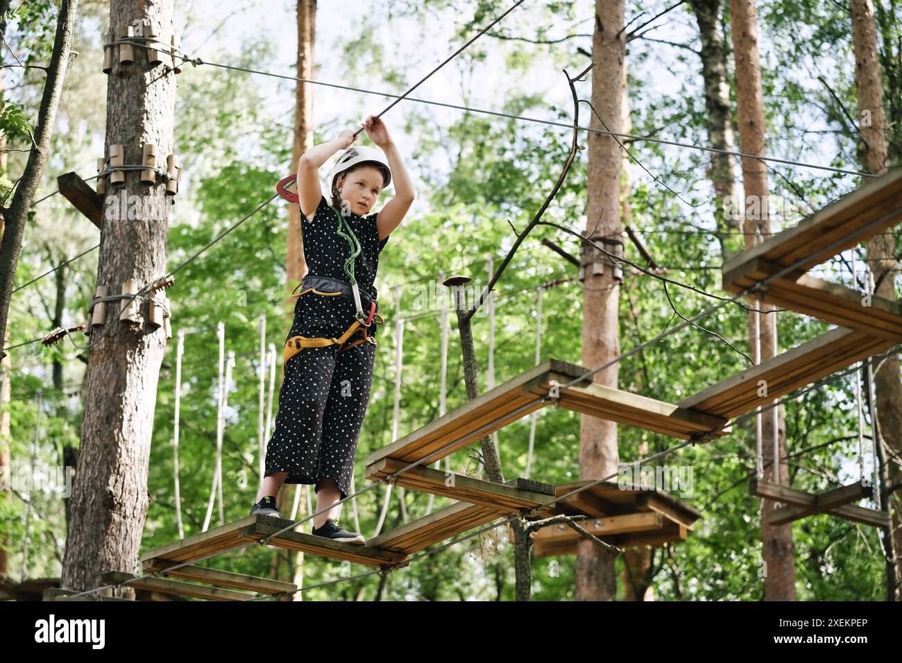 Girl climbs and having fun at outdoor adventure rope park. Active ...