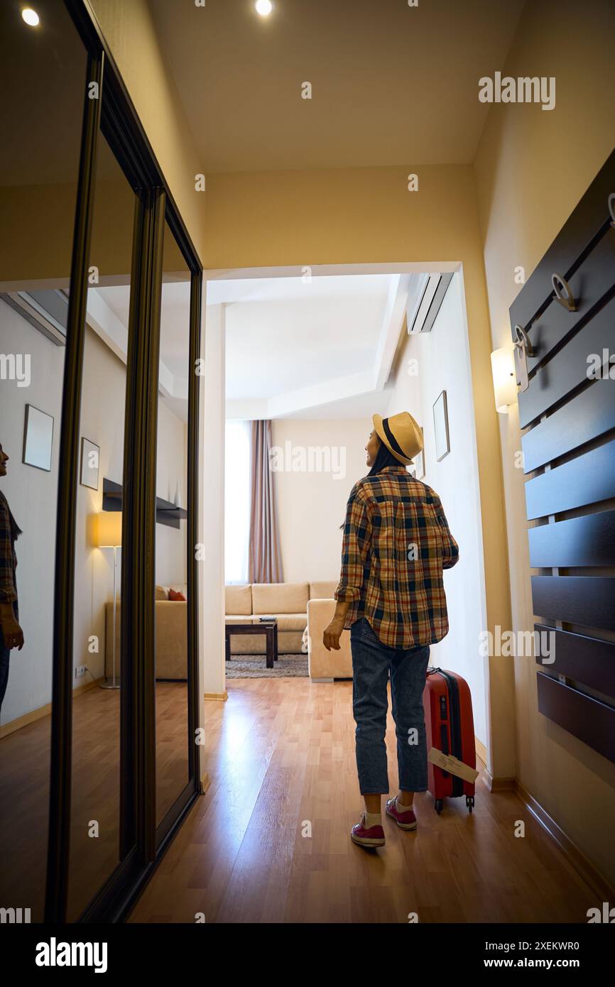 Tourist with baggage looking around in hotel room on arrival Stock ...