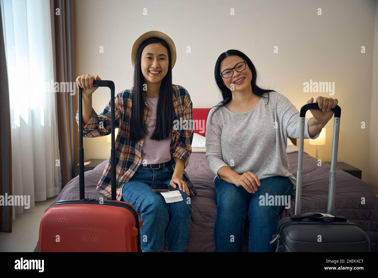 Contented Asian tourists sitting in suite upon arrival Stock Photo - Alamy