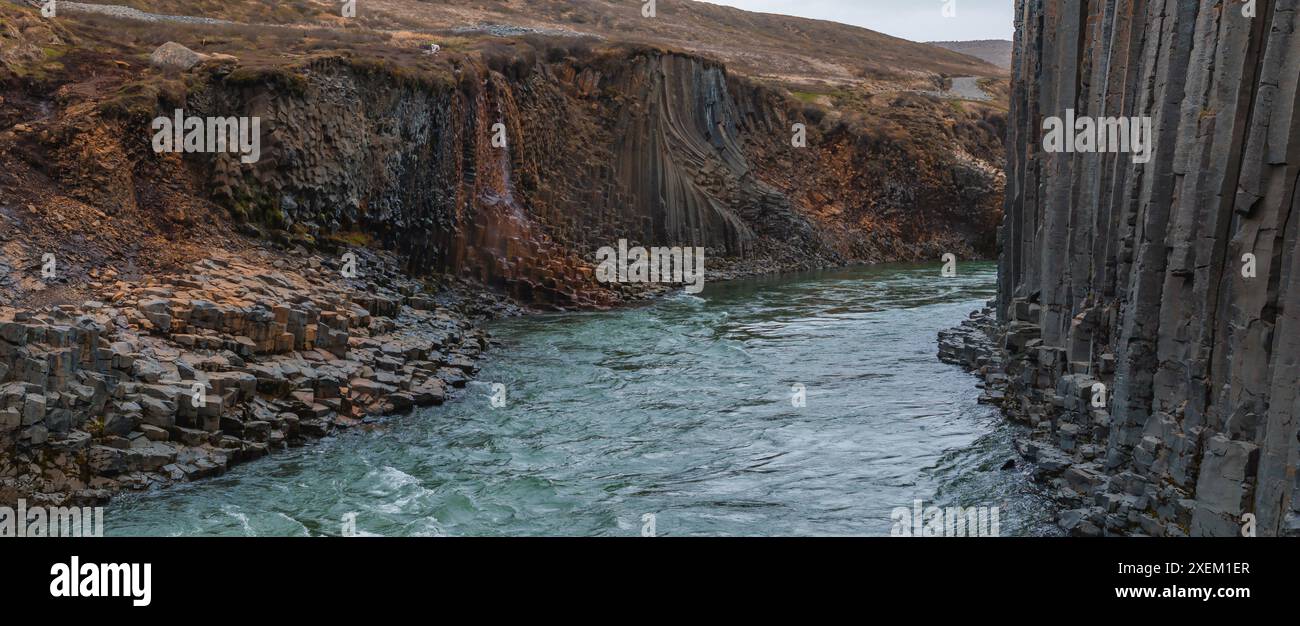 Aerial View of River Flowing Through Canyon with Tall Basalt Columns in ...