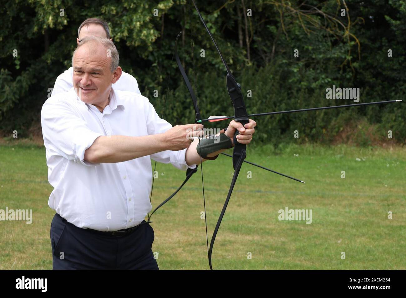 Liberal Democrat leader Sir Ed Davey tries his hand at archery in Little Paxton, Cambridgeshire ...