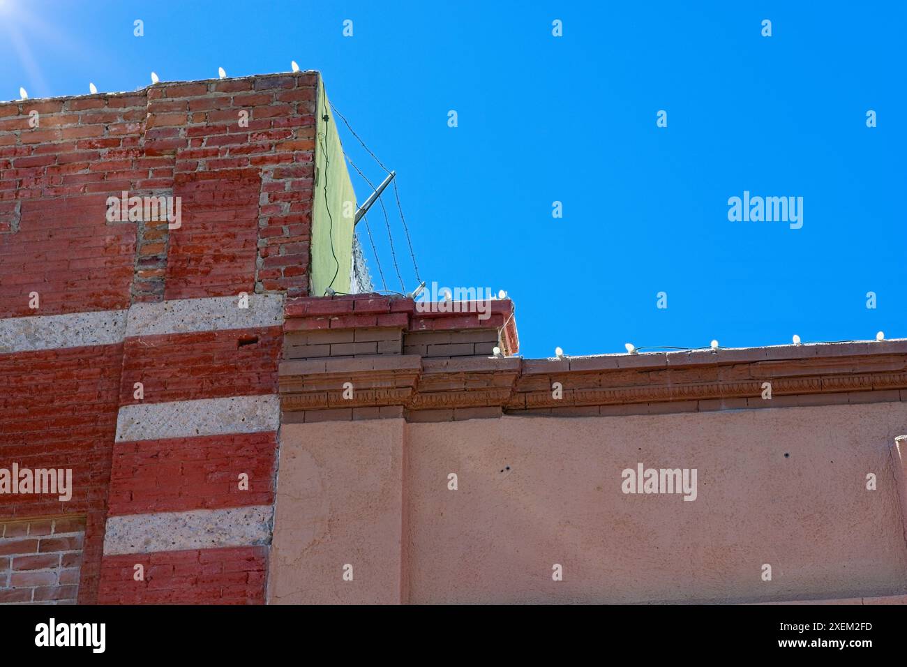 Roofline and walls of old brick buildings with bricked over window in ...
