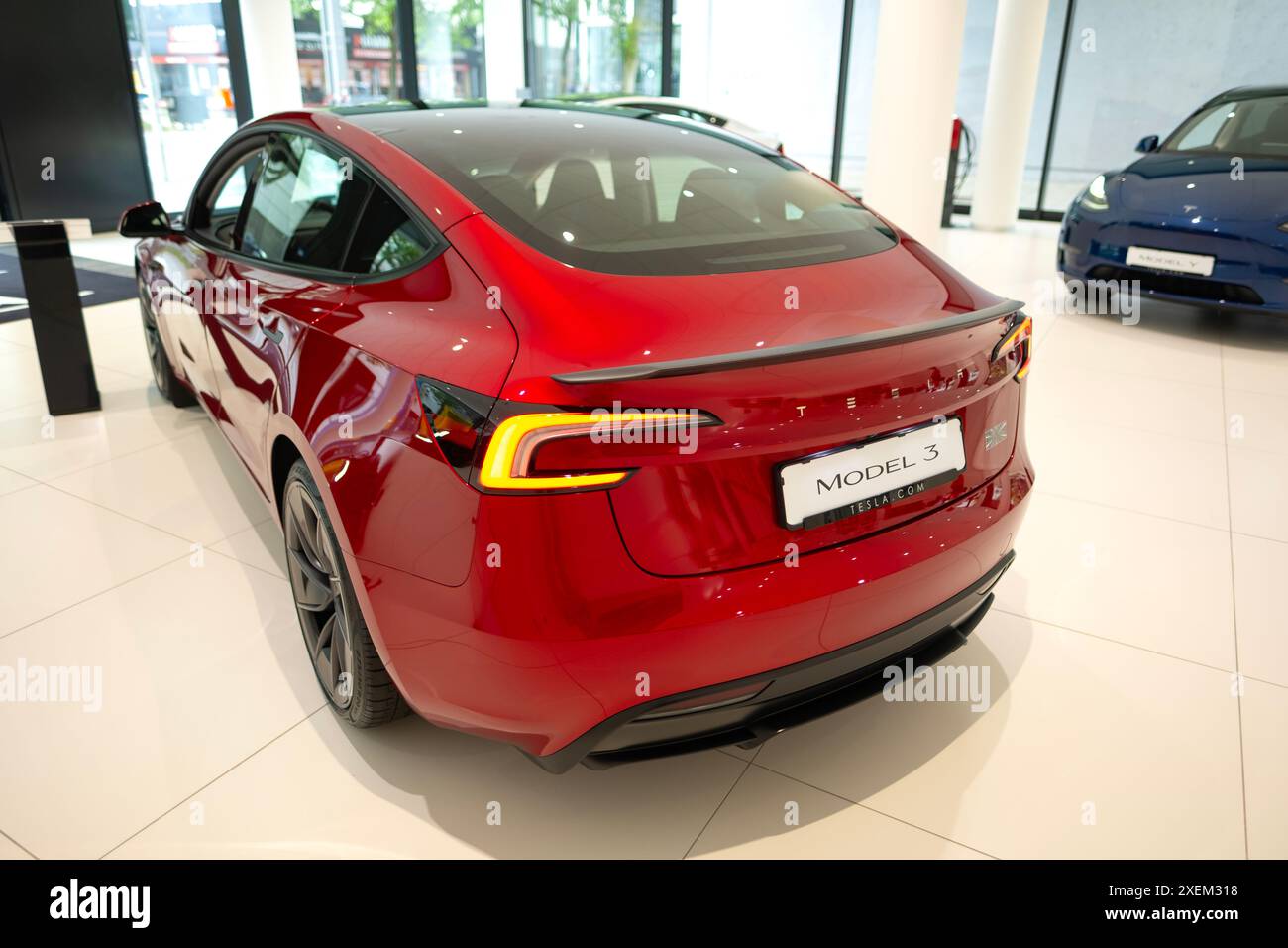 red electric Model 3 Performance Highland facelift car in showroom ...