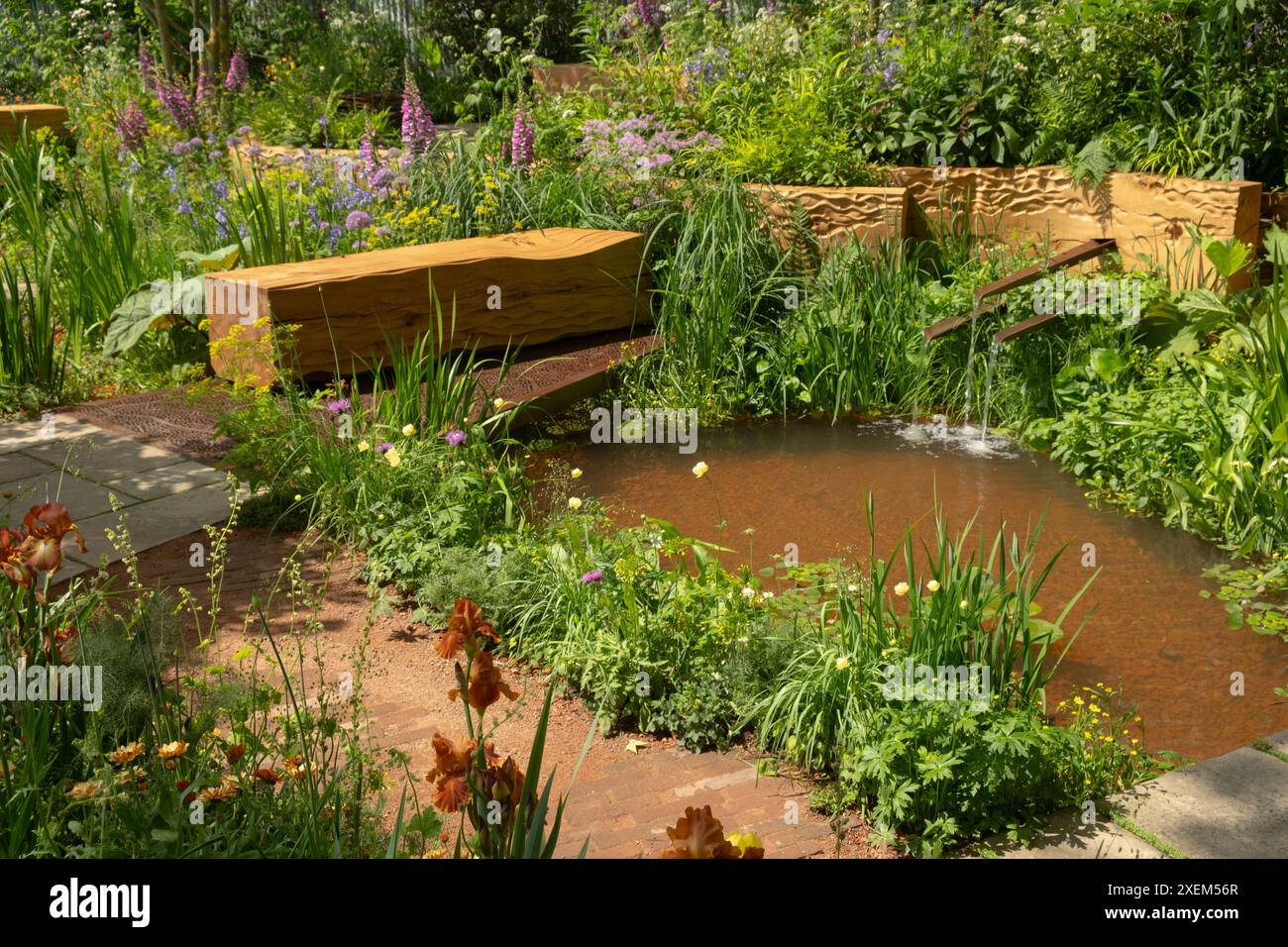 A pond with water chutes surrounded by carved oak benches and ...