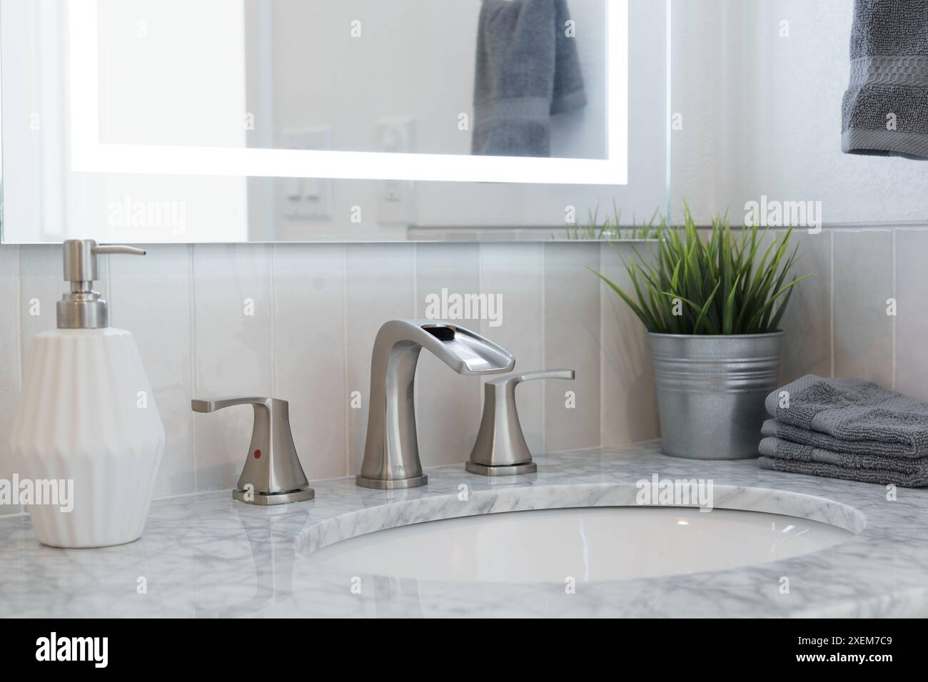 modern bathroom sink with marble countertop, brushed nickel faucet, and ...