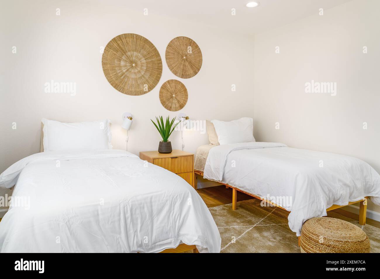 boho modern bedroom with two twin beds, side table, rug, and wicker ...