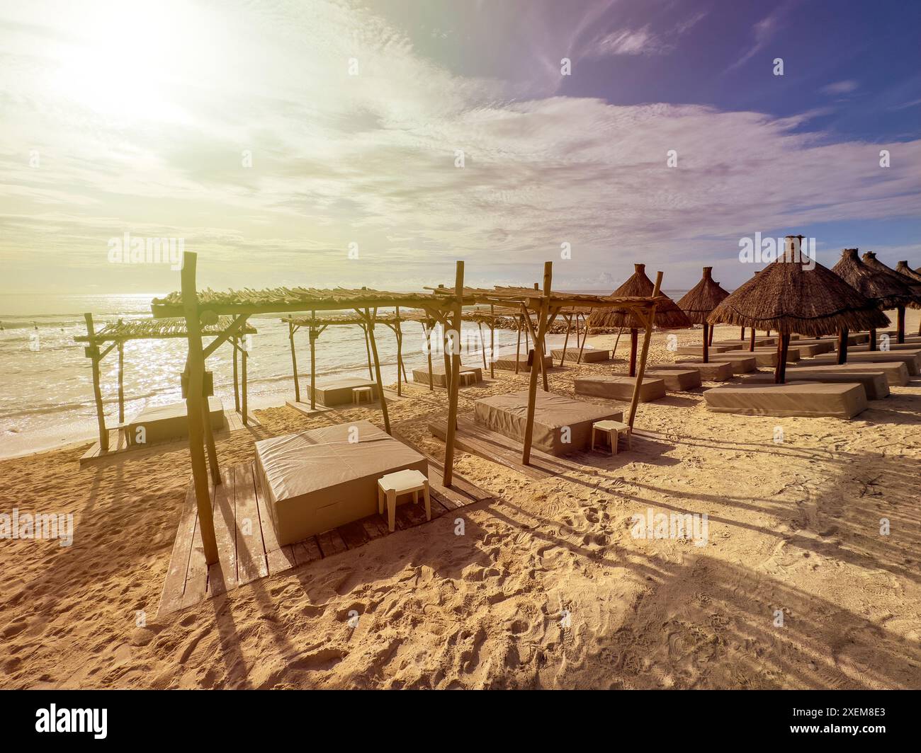 Balinese beds on a beach of fine golden sand under a glittering ...