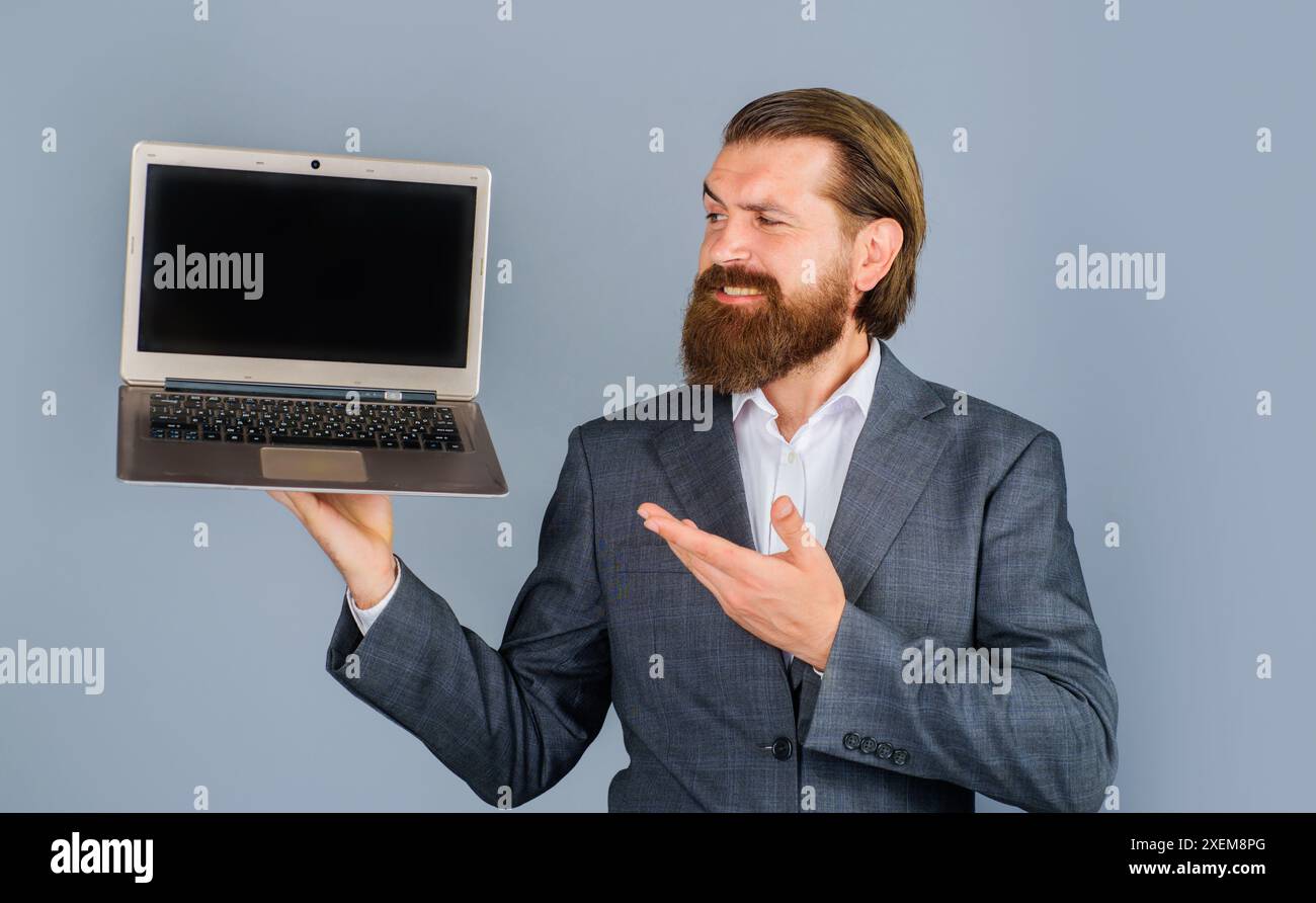 Bearded business man in suit showing laptop computer with blank mockup ...