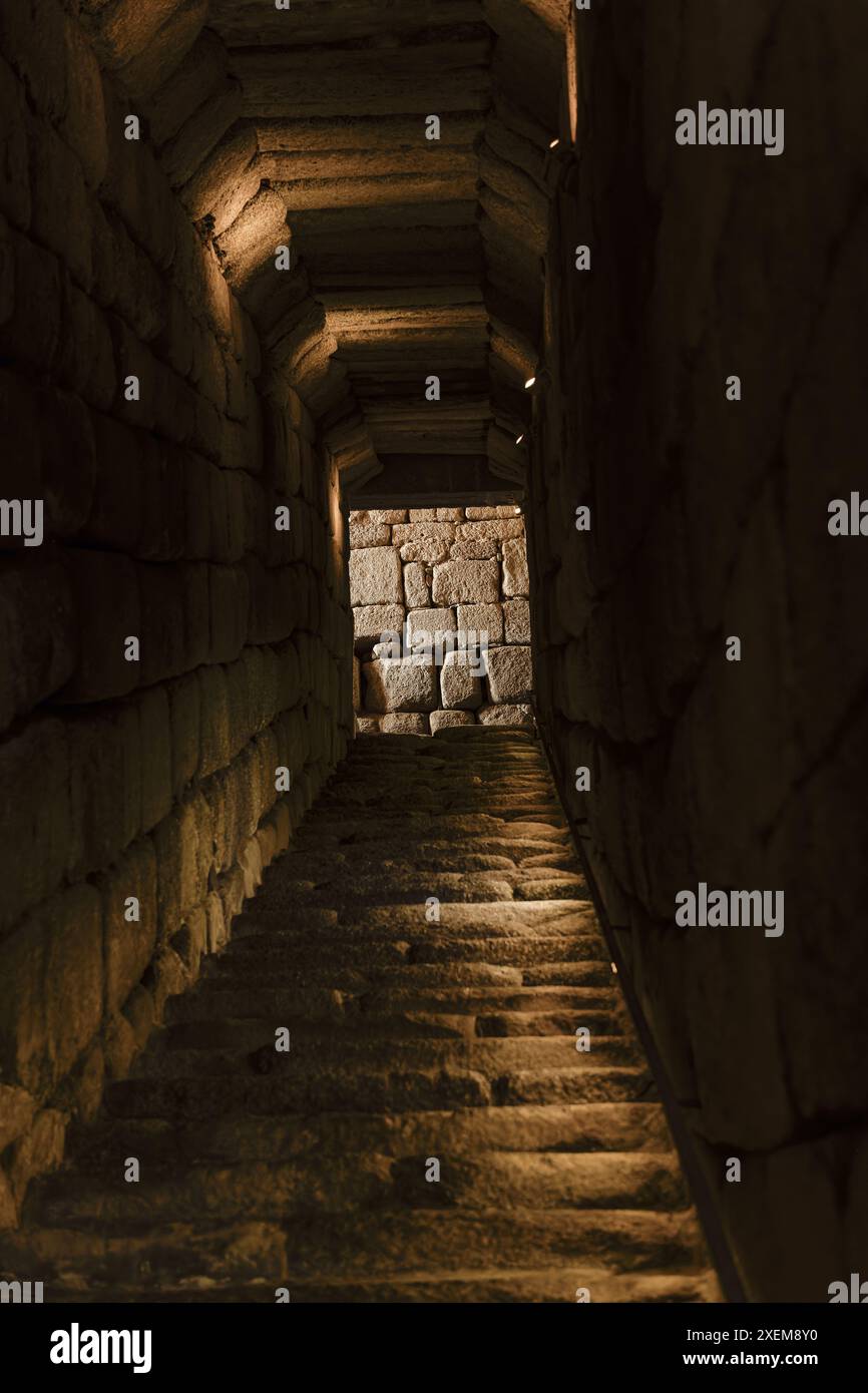 A dimly lit stone passageway leading to an ancient structure in Merida ...