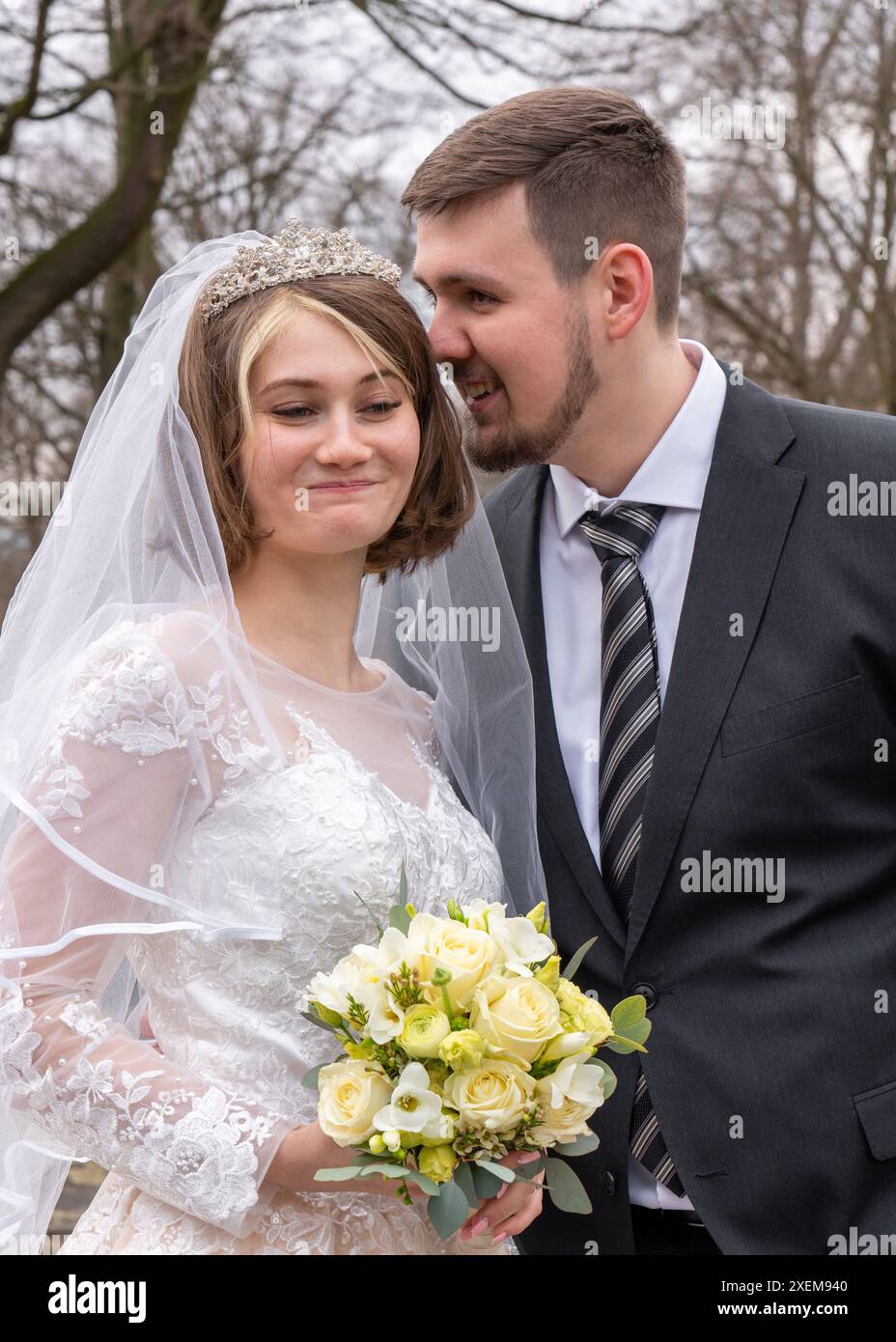 Wedding portrait of a young beautiful modern couple. The groom hugs the ...