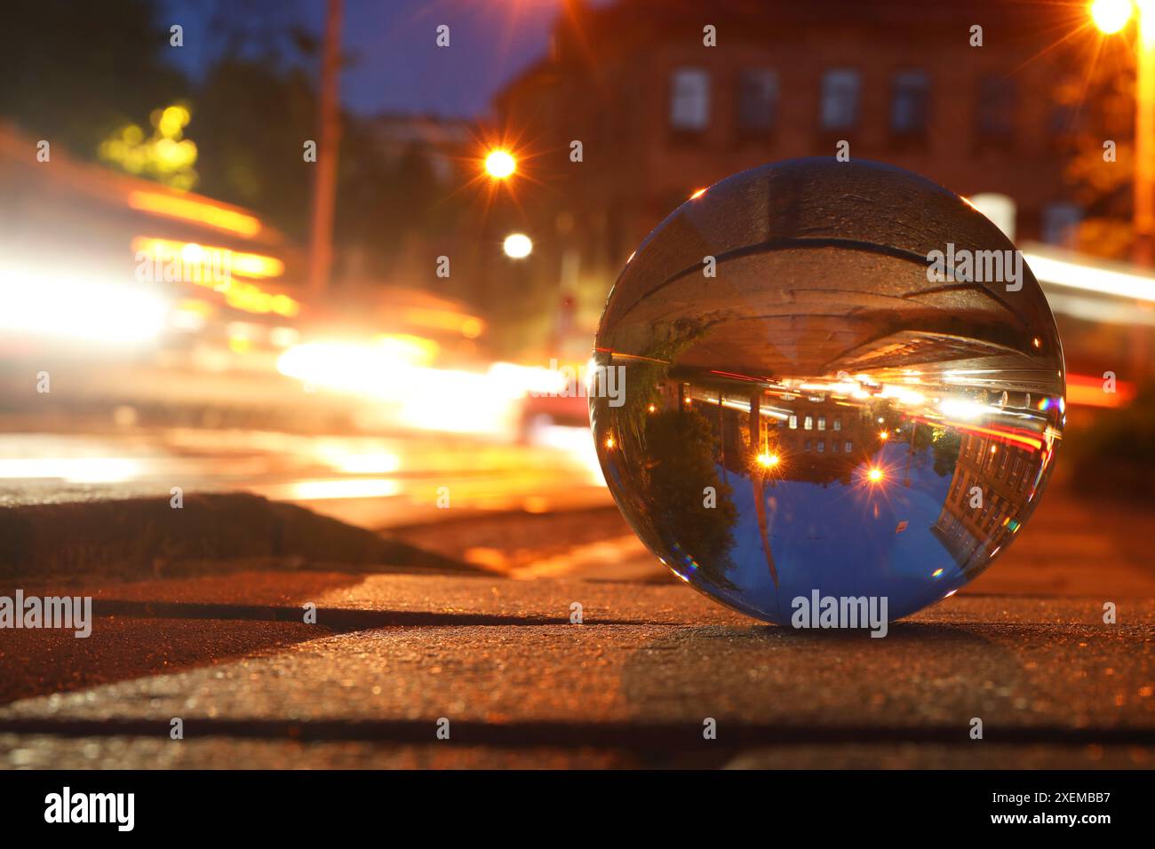 Beautiful city street, overturned reflection. Crystal ball on asphalt ...