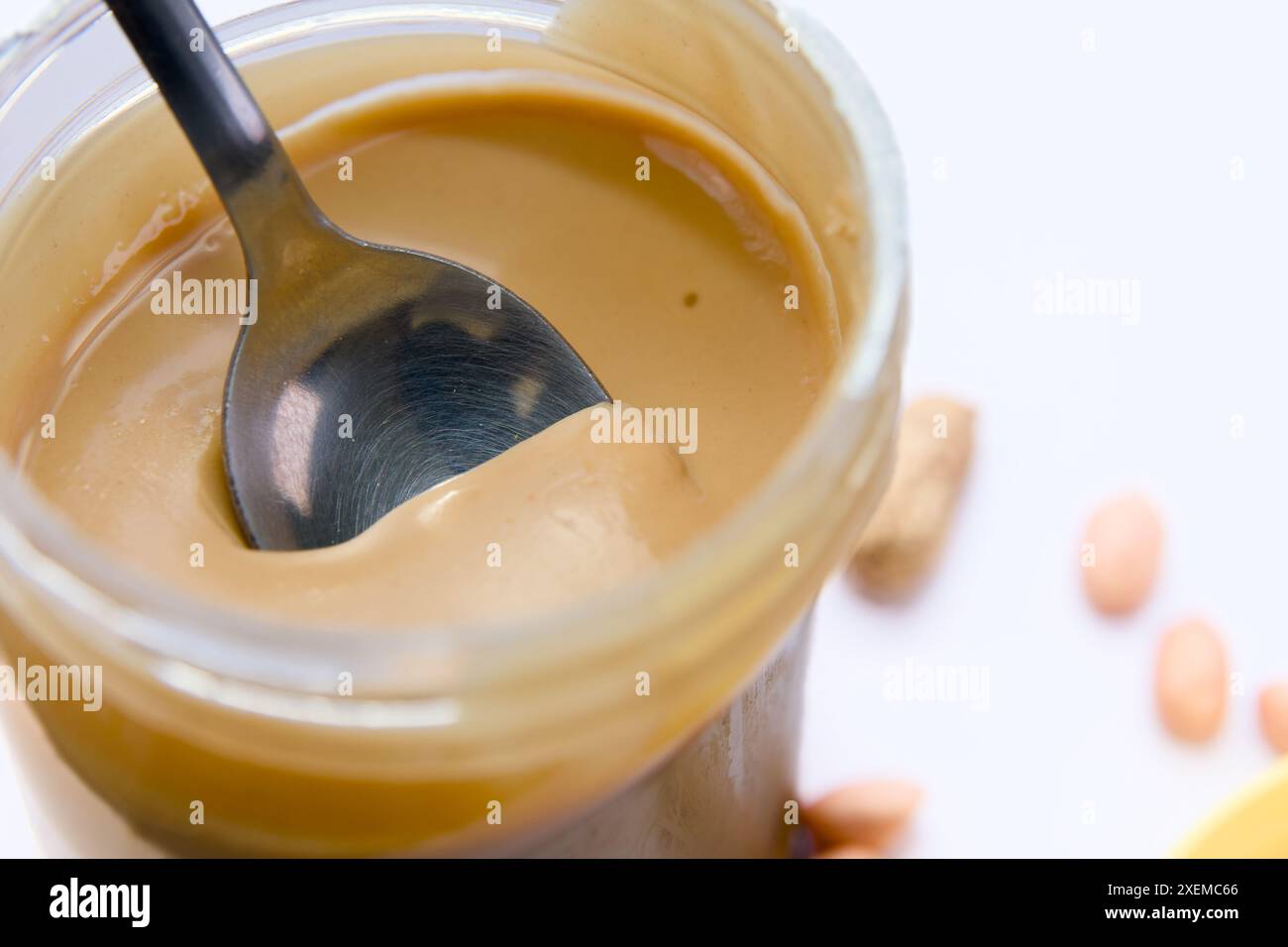 A close-up photo of a heaping spoonful of creamy peanut butter lifted ...