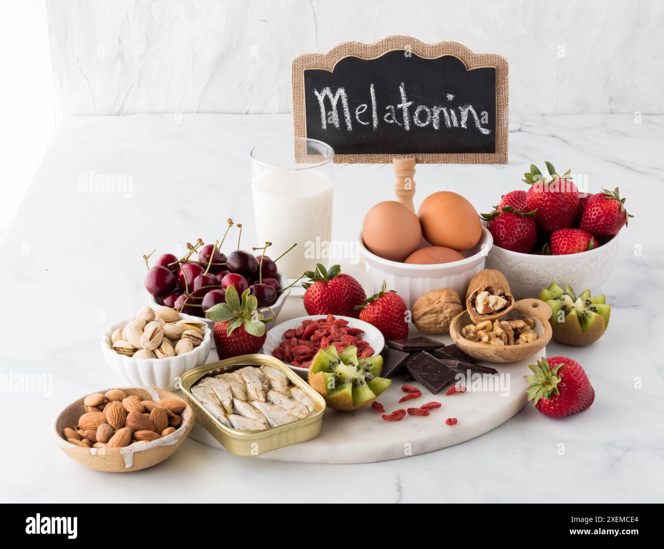 A collection of foods high in melatonin arranged against a light ...