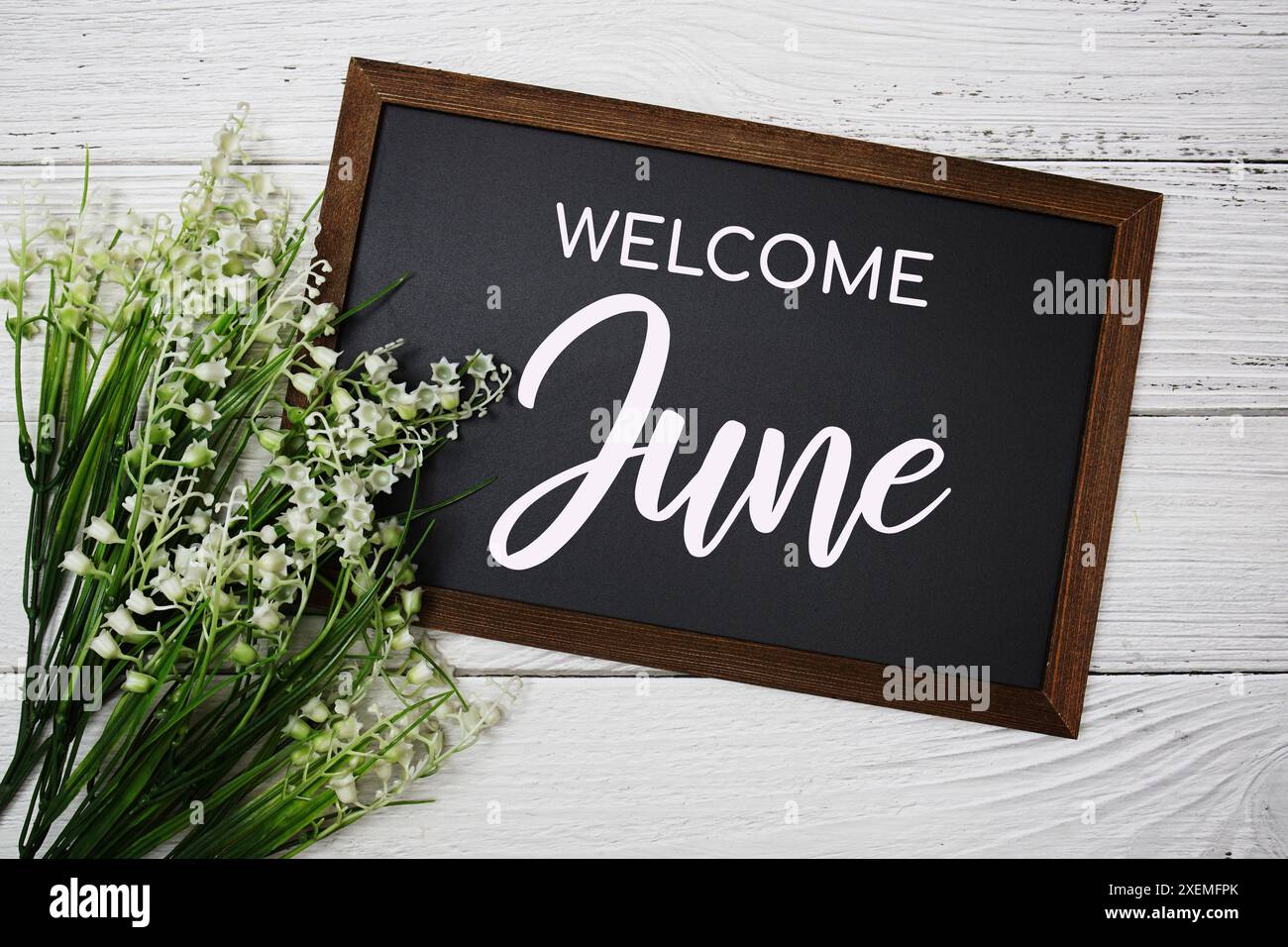 Welcome June text on chalkboard with flowers decoration top view on ...