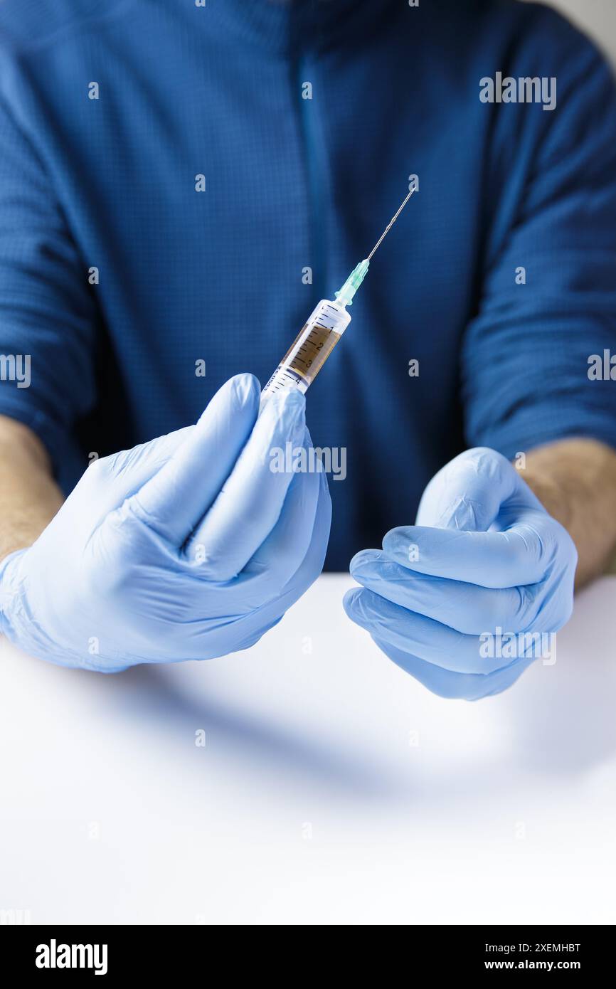 The hands of the doctor or nurse, on a white table and wearing blue ...
