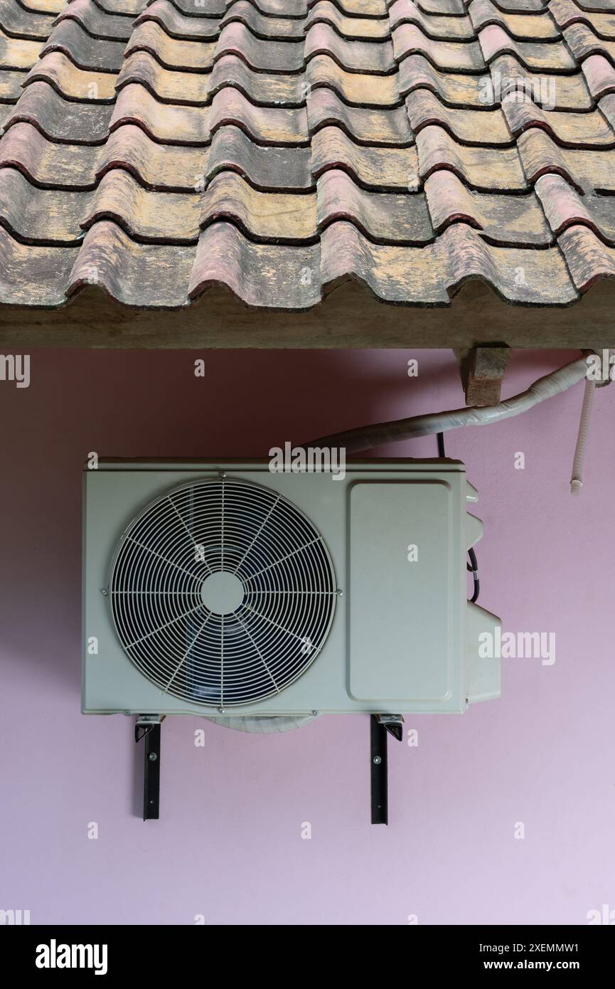 Ac outside with pipe connection home unit under roof tiles Stock Photo ...