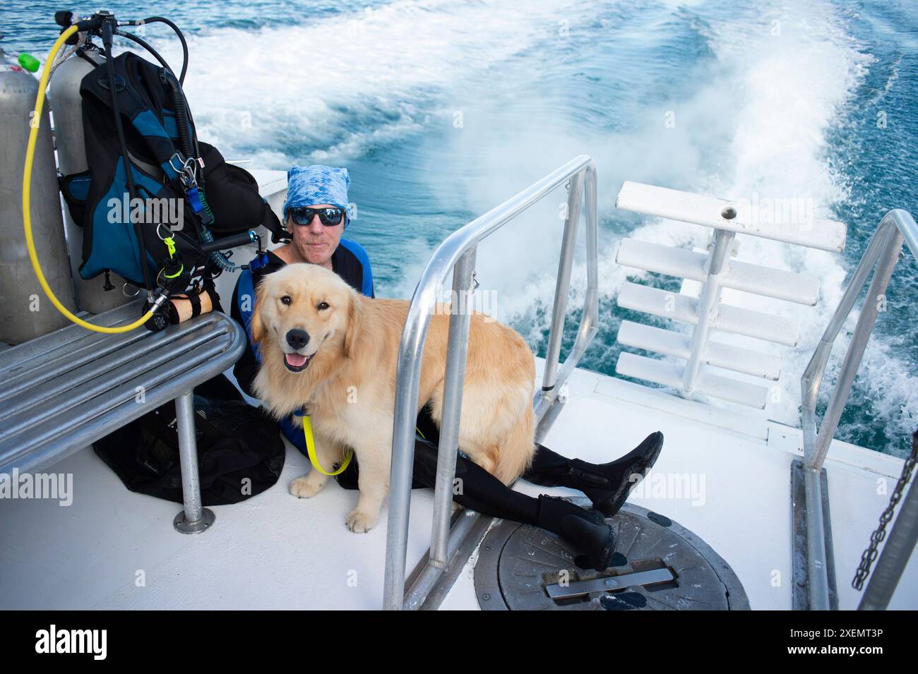 Paraplegic man and his service dog riding in the back of a dive boat ...