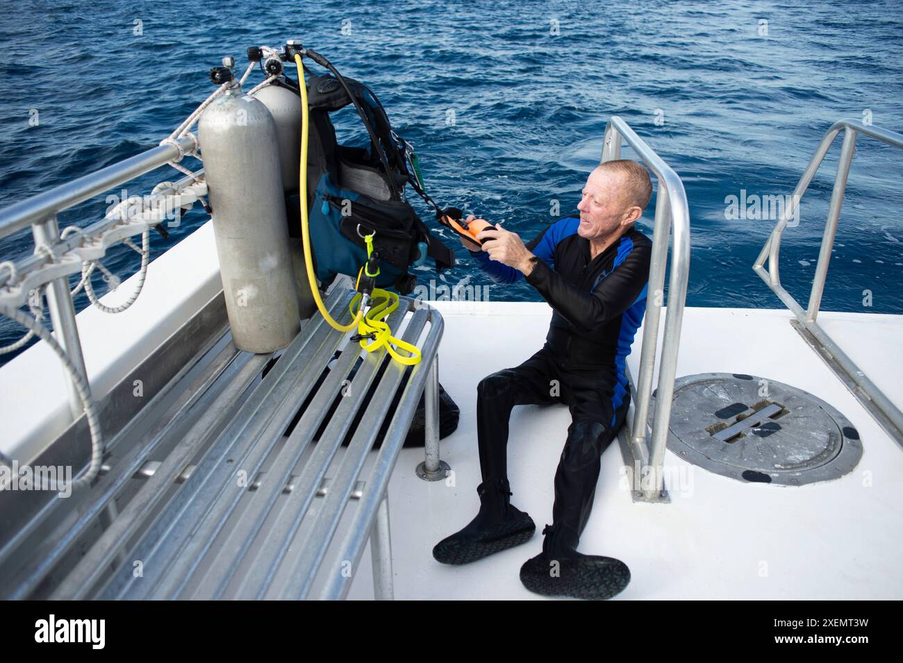 Paraplegic man preparing to scuba dive on the back of a dive boat ...