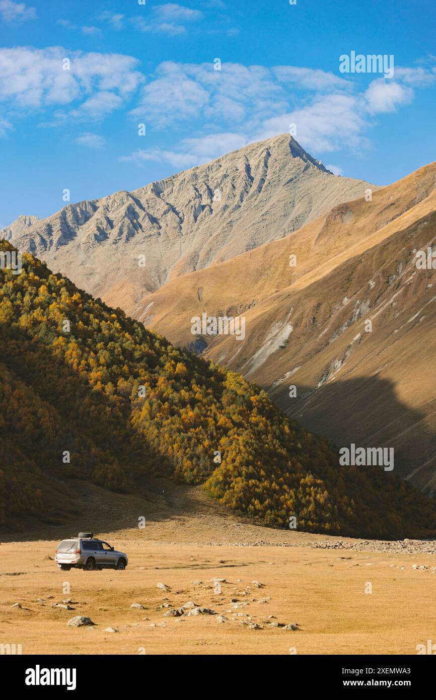 Autumn colours at Truso Gorge with a vehicle moving through the valley ...