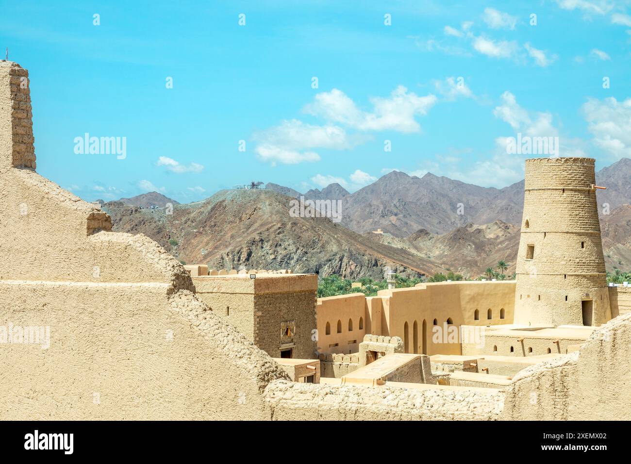 Bahla citadel fortress stone walls and round towers with mountains in ...