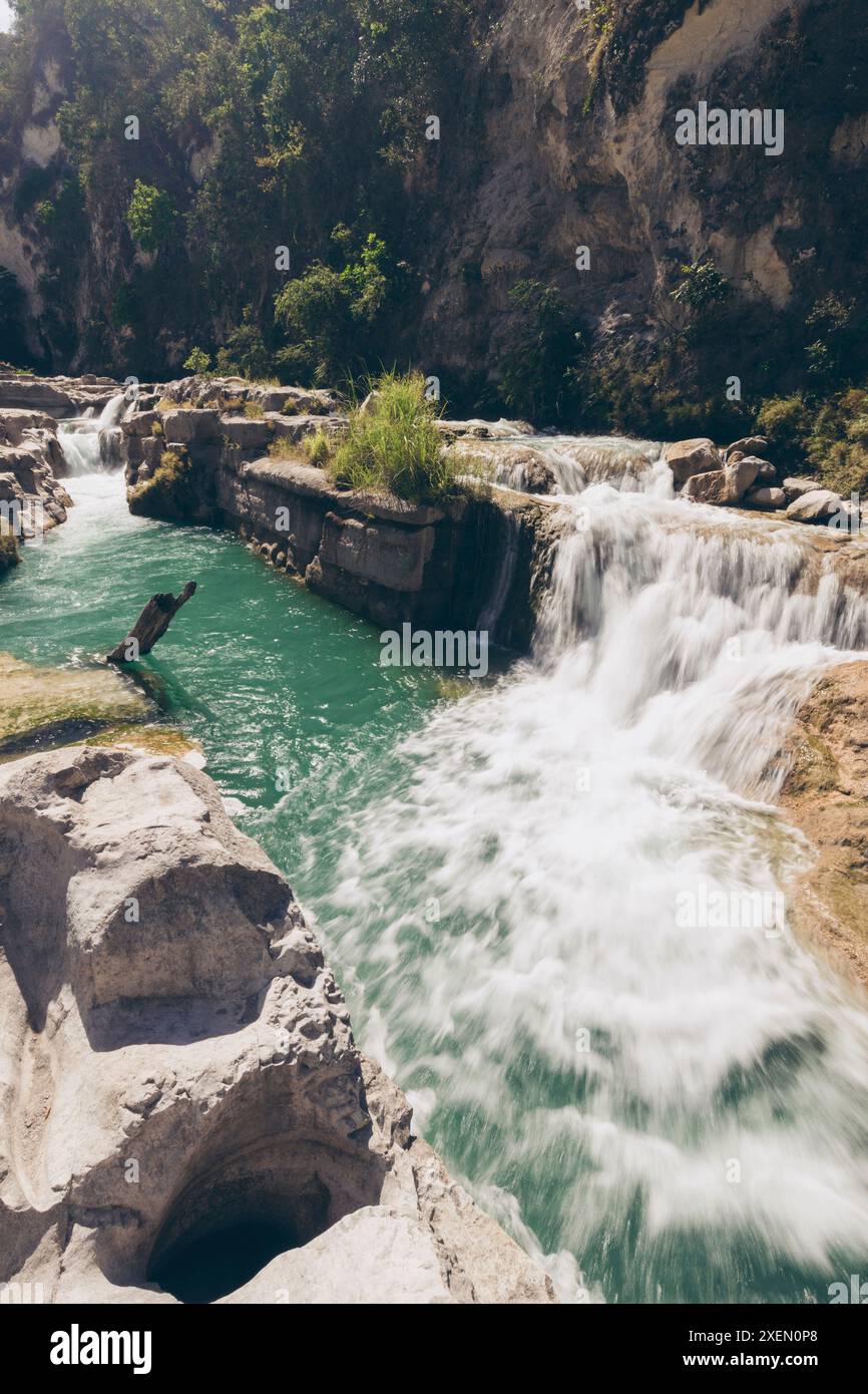 Cascades splash over a rocky landscape at Air Terjun Tanggedu ...