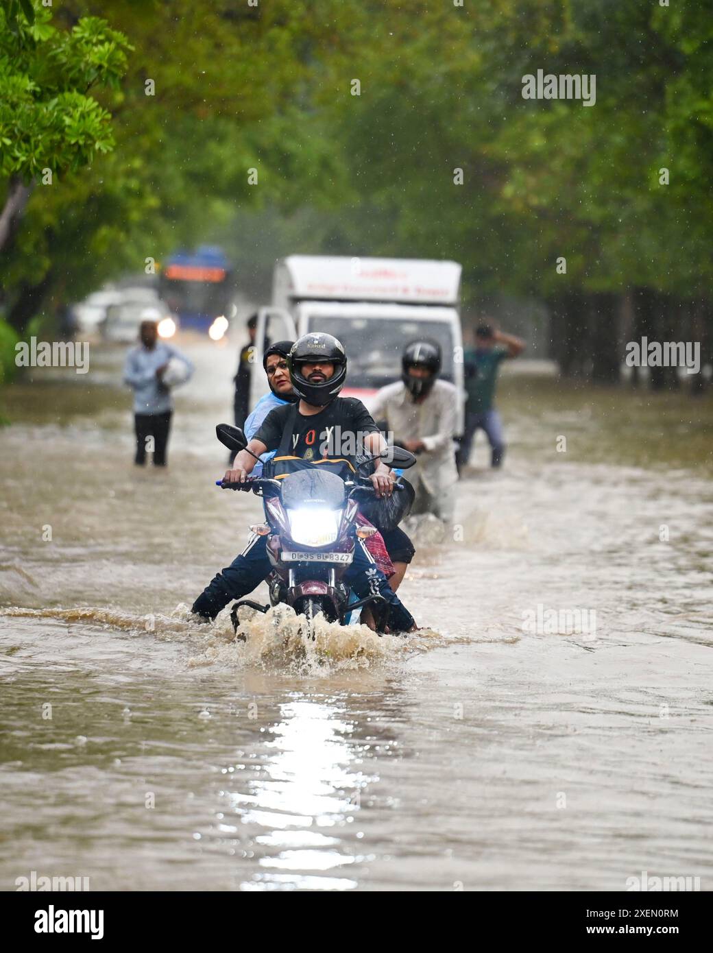 NEW DELHI, INDIA - JUNE 28: Commuters wade through water logging at ...