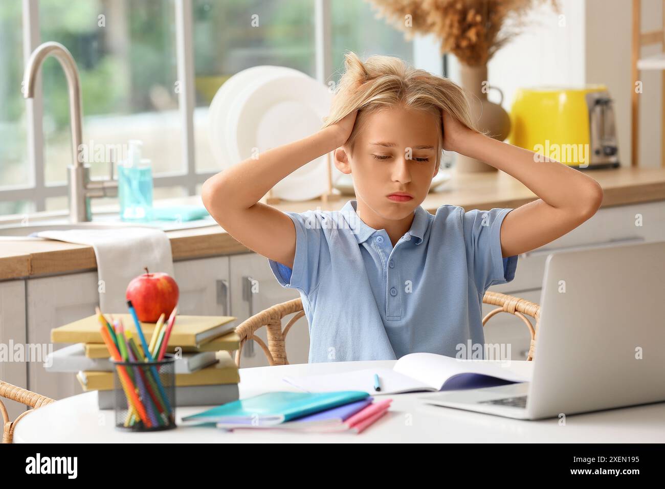 Stressed little boy doing homework in kitchen Stock Photo - Alamy