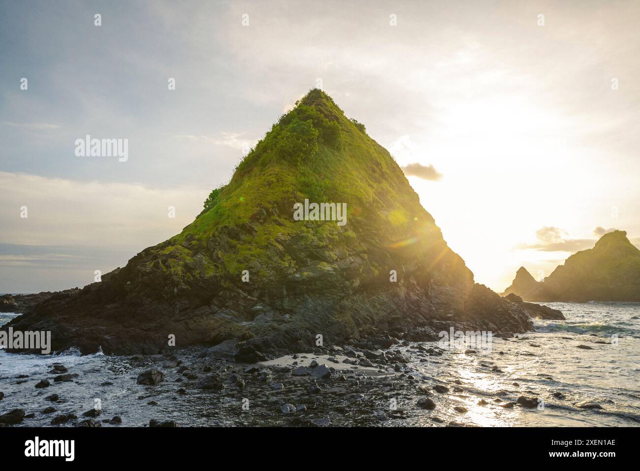 Peaked landforms and sunset light along a rugged Indonesian island at ...