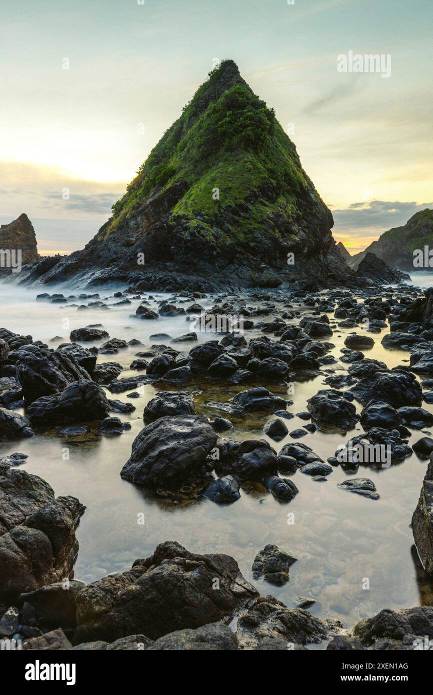 Peaked landforms and sunset light along a rugged Indonesian island at ...