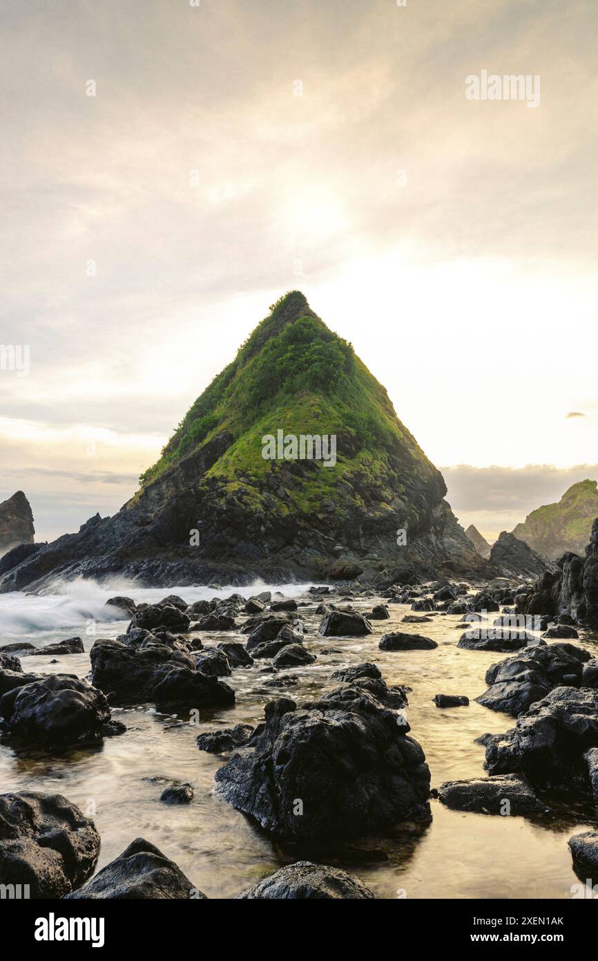 Peaked landforms and sunset light along a rugged Indonesian island at ...