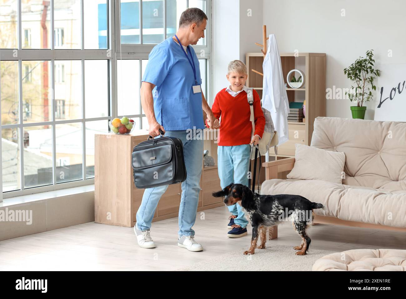 Mature doctor with his little son and cocker spaniel at home Stock ...