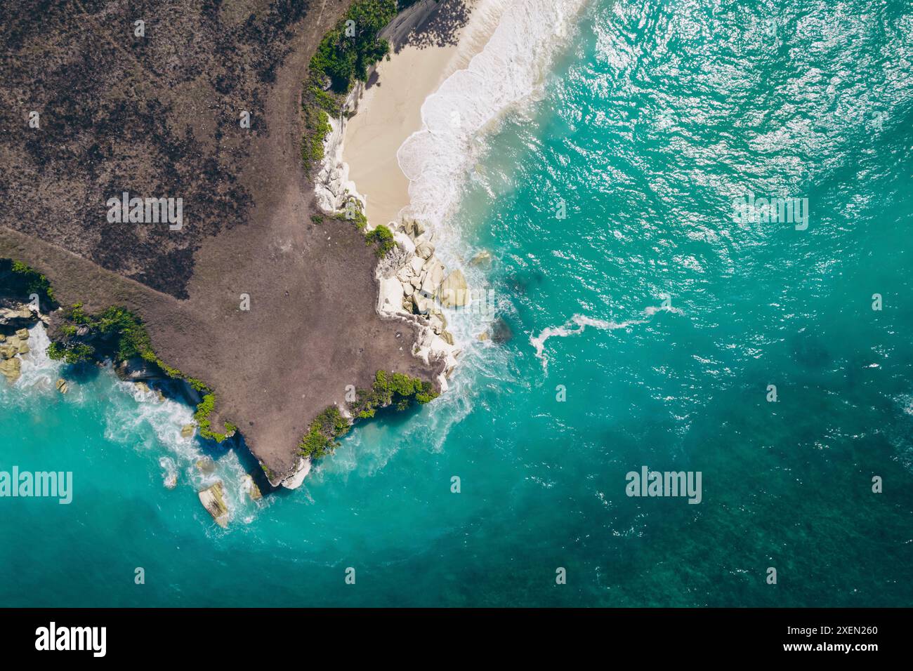Aerial view of barren land above Mbawana Beach, with surf and turquoise ...