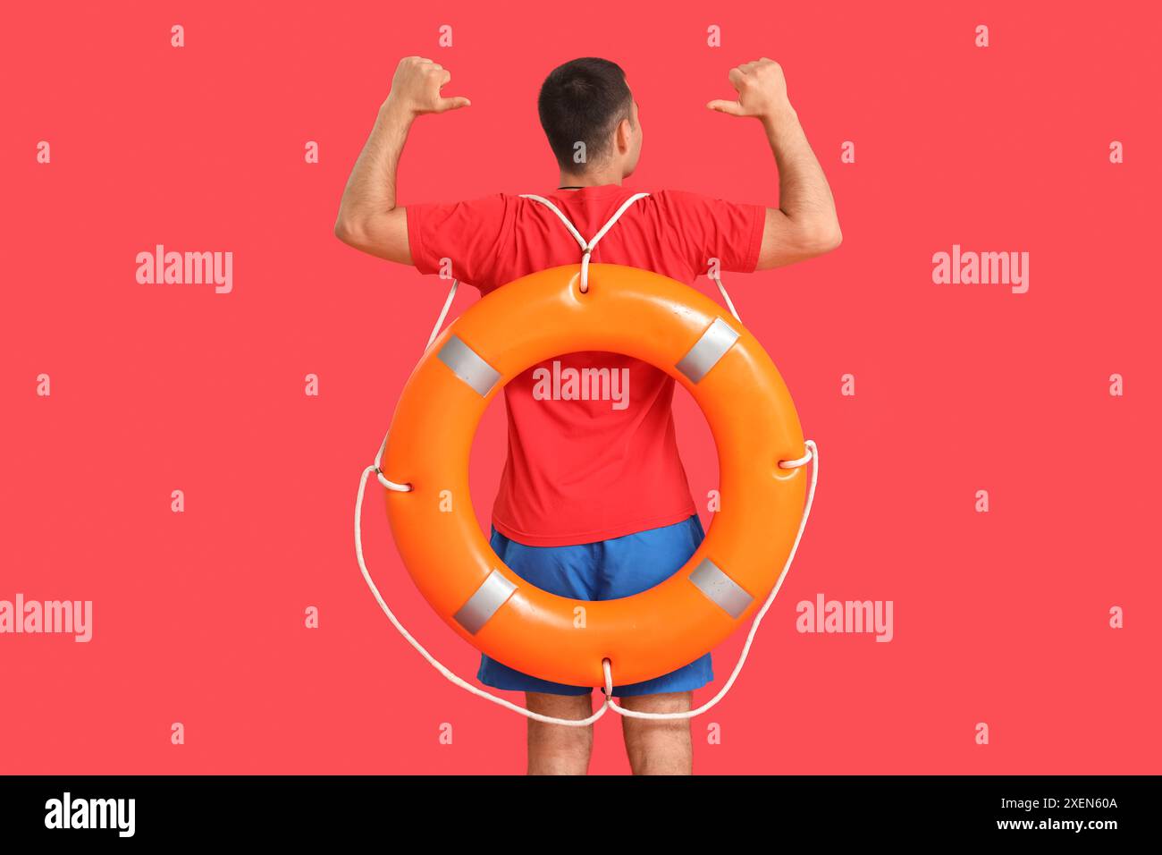 Handsome male lifeguard with ring buoy on red background, back view ...