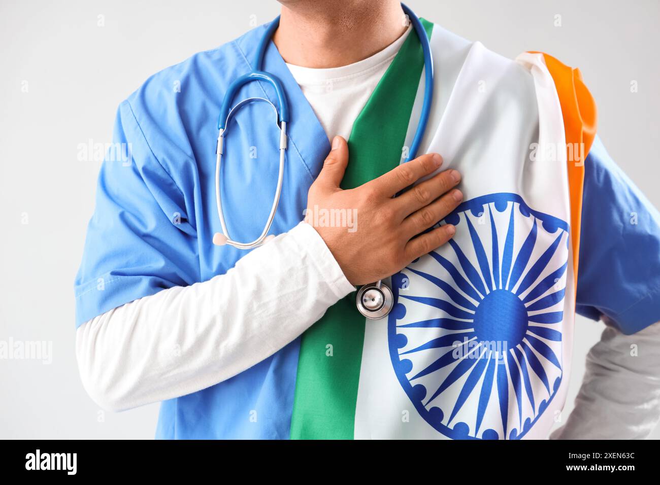 Male doctor with flag of India holding hand over heart on grey ...