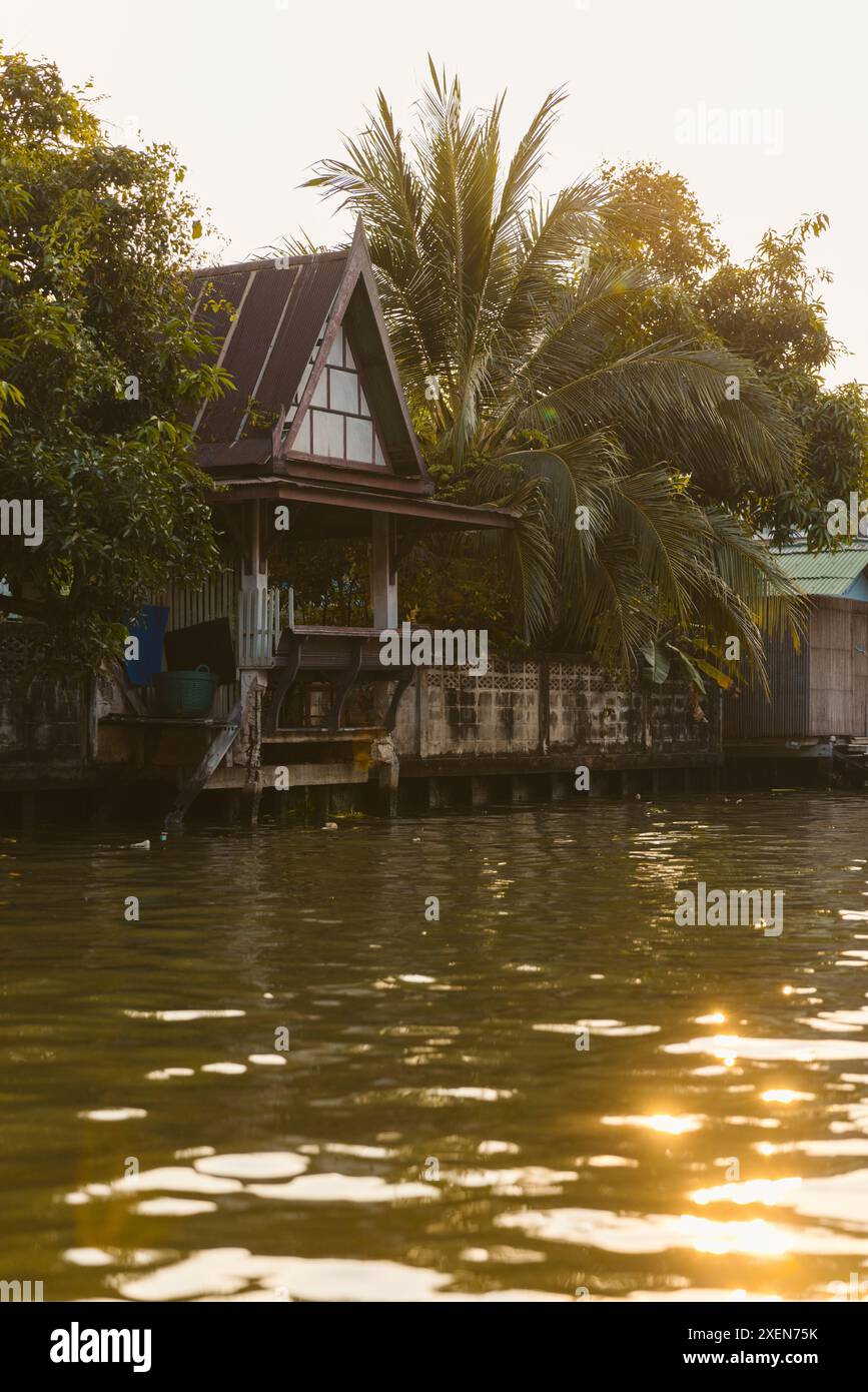 Typical canal-side home in the Bangkok Noi Area surrounded by trees ...