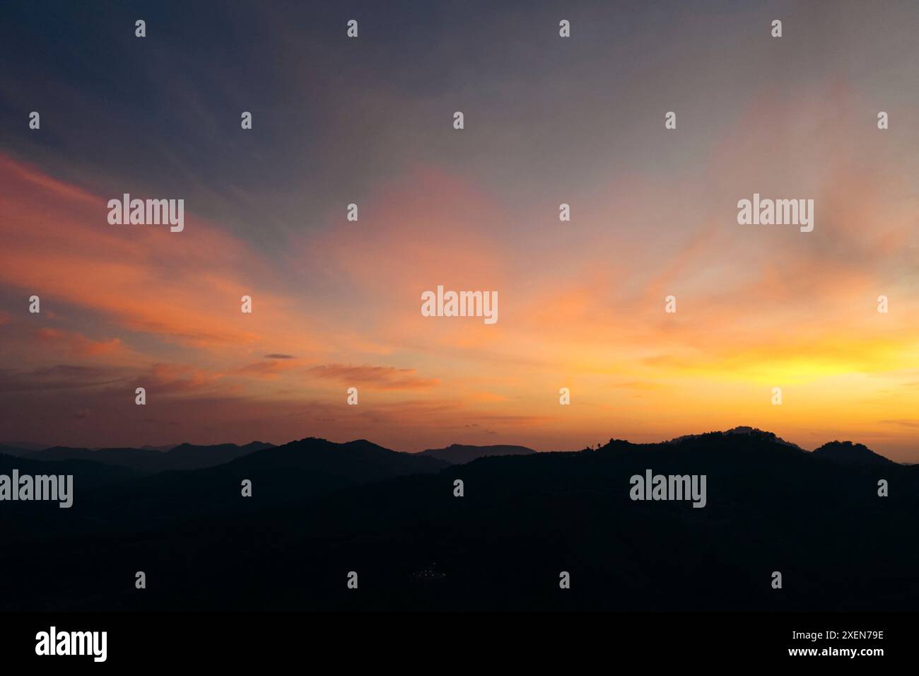 Colourful sunset sky glowing over silhouetted mountains on the ...