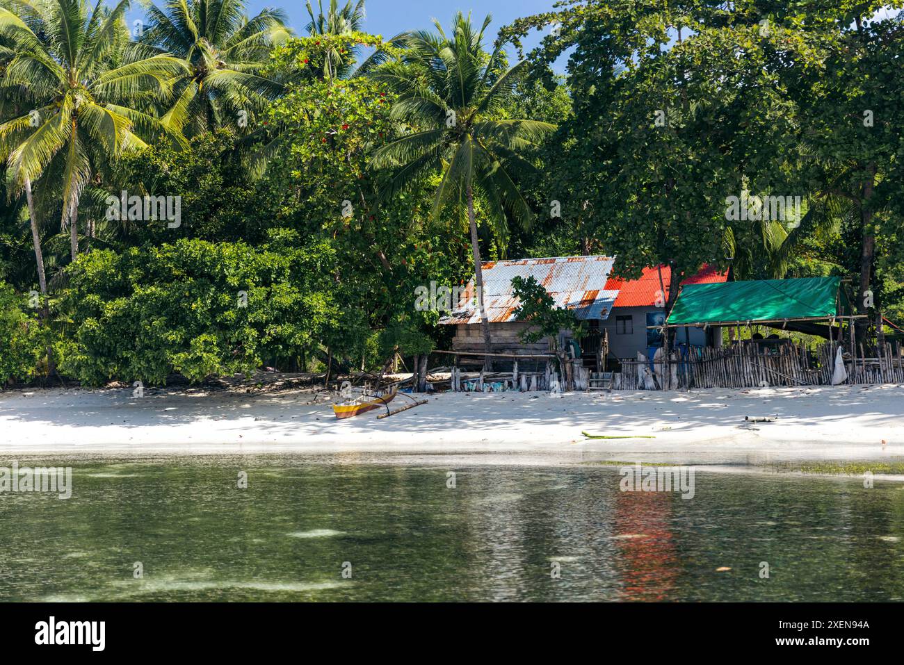 Patokan Beach (Jiko) with palm trees and buildings along the water's ...