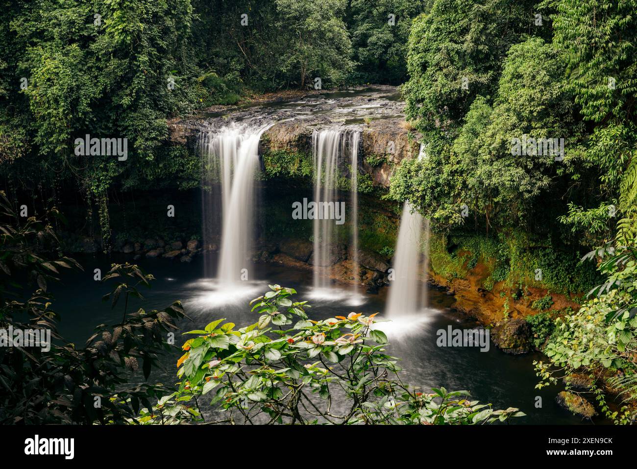 Long exposure of three waterfalls and lush foliage at Tad Champee ...