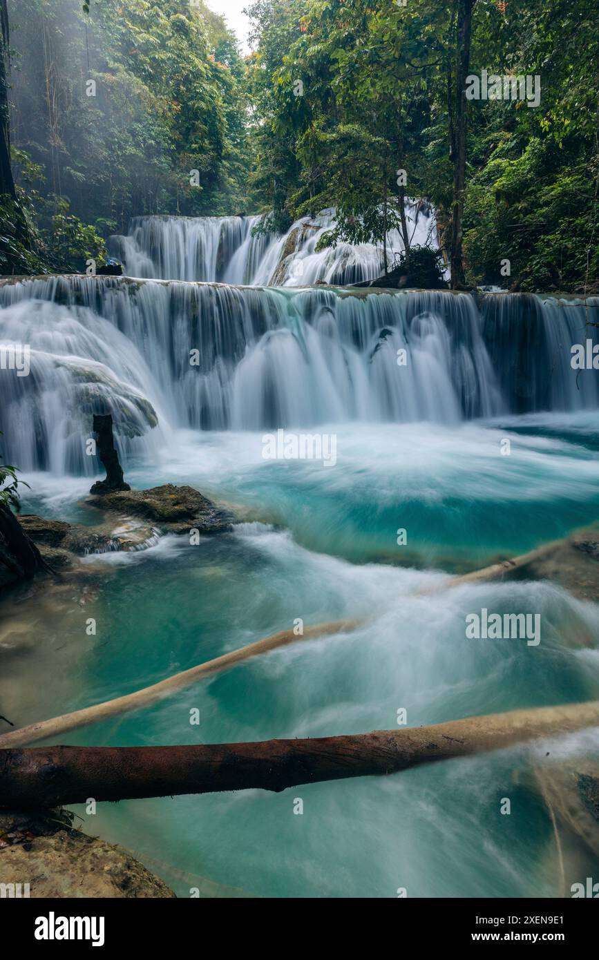 Long exposure of Piala waterfall cascading over rock with lush foliage ...