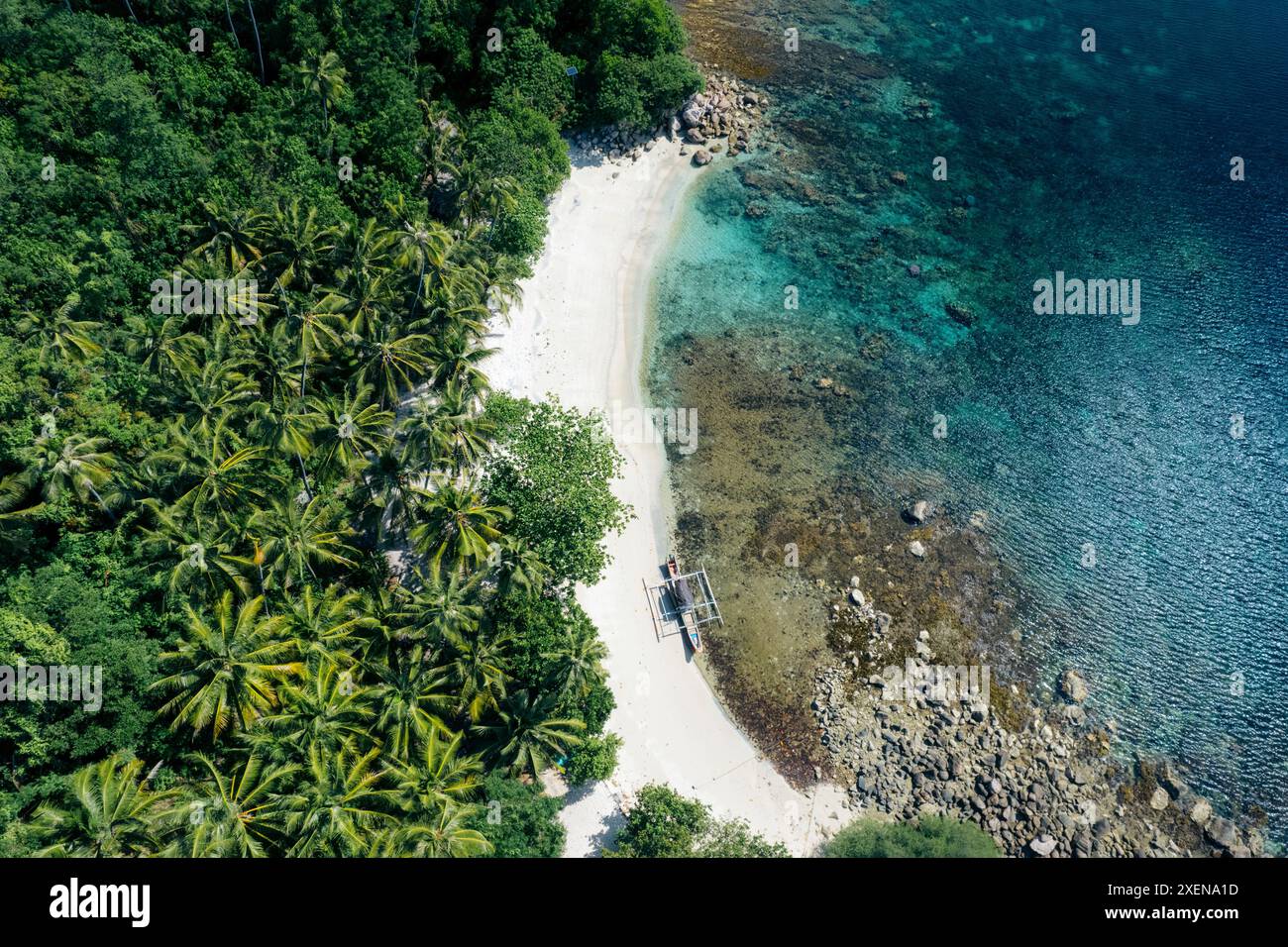 Patokan Beach (Jiko) with a boat on the white sand beach and palm trees ...