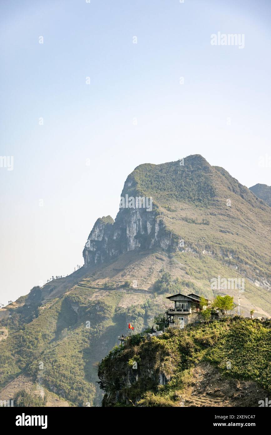 Lone house on a ridge looking out to a mountainous landscape along the ...