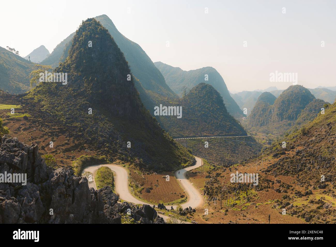 Road with switchback curves winding through a valley with peaked ...