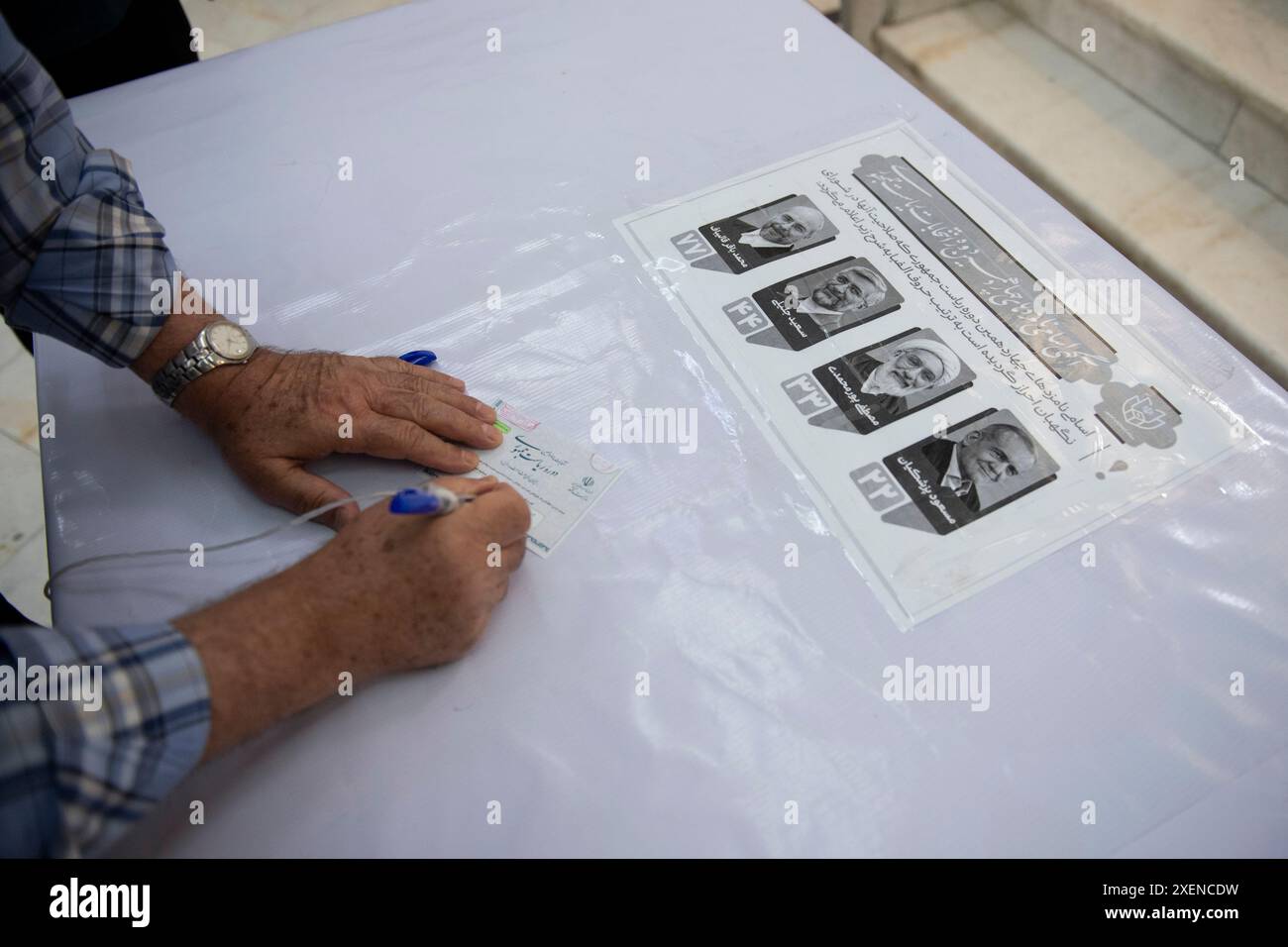 Tehran, Iran. 28th June, 2024. A man fill out his ballot during the ...