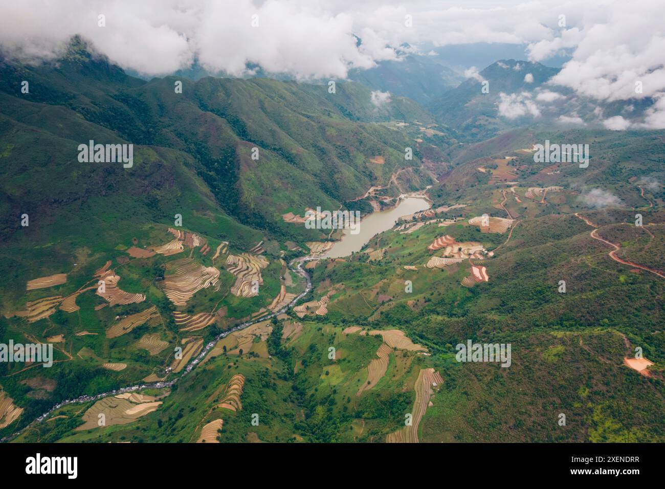 Terraced farmland with a lake and river in the valley of a mountainous ...