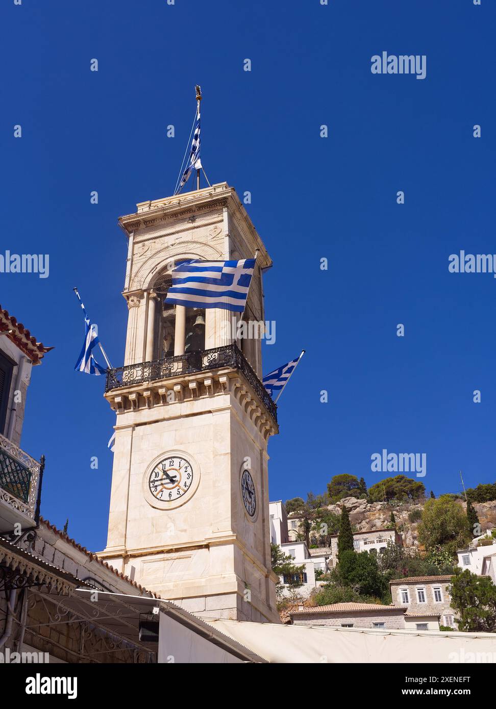 Hydra island church bell tower with greek flags in a sunny day under ...