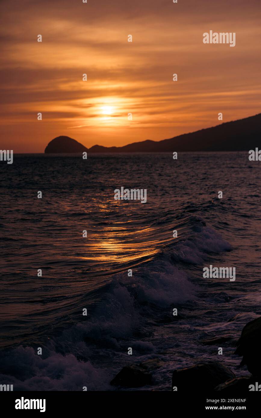 Soft waves reflecting sunset light from a golden sky; Bai Nhat, Con Dao ...