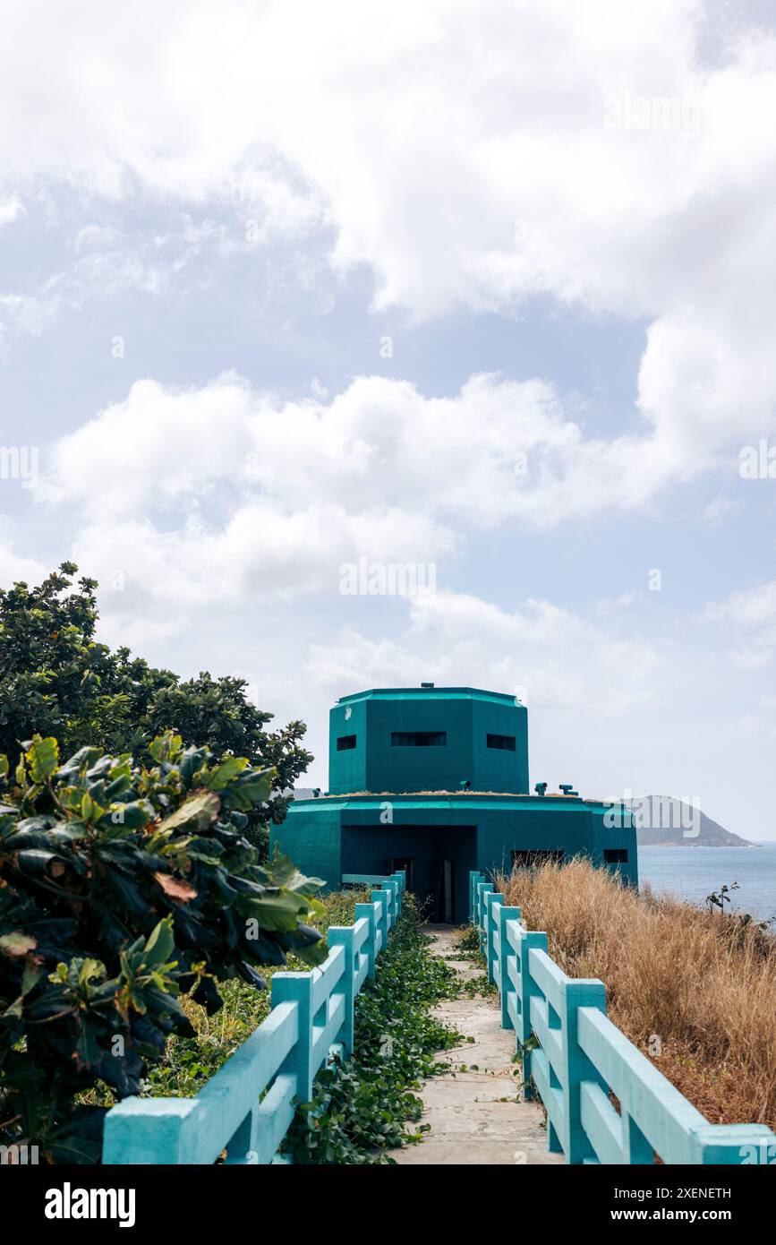 Blue building and blue railings along a walkway on the coast of an ...