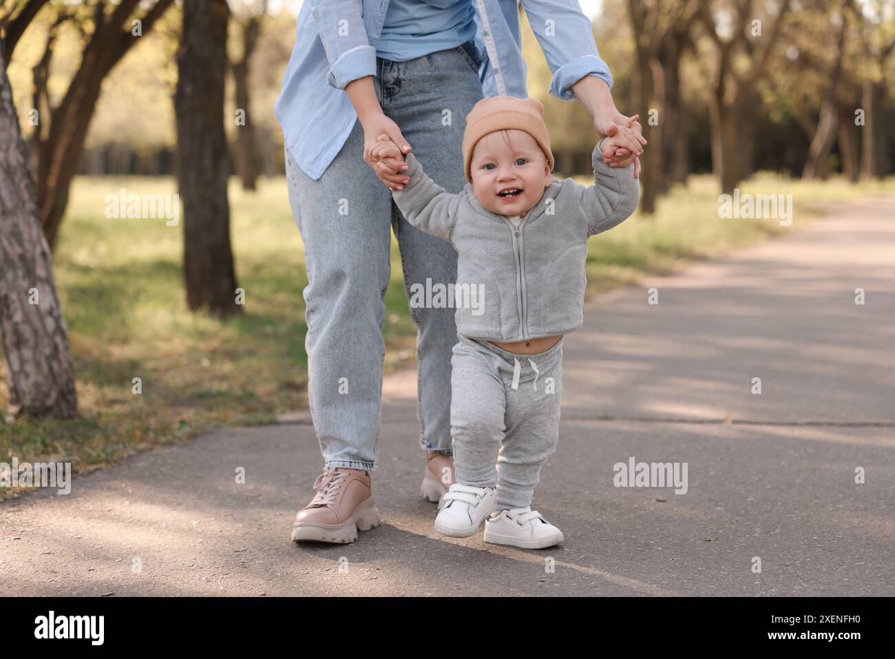 Mother teaching her baby how to walk outdoors, closeup Stock Photo - Alamy