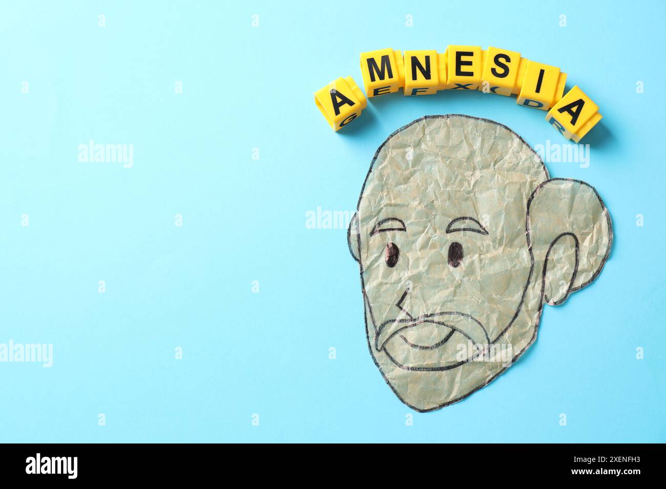 Yellow cubes with word Amnesia and human face made of crumbled paper on ...